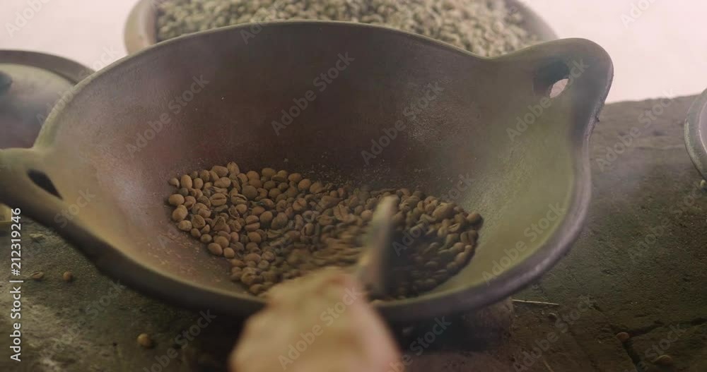 Manual production of coffee in which a stone container is crushed by ...