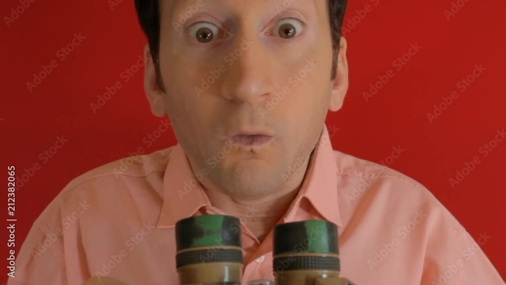 Vidéo Stock A funny ugly man looking through a pair of military ...