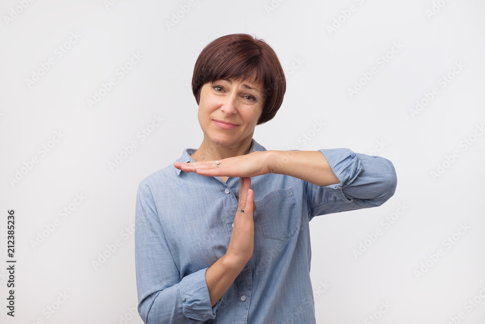 Middle aged woman in blue shirt tired and bored, making a timeout ...