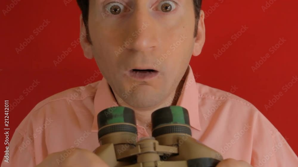 A funny ugly man looking through a pair of military binoculars, seeing ...