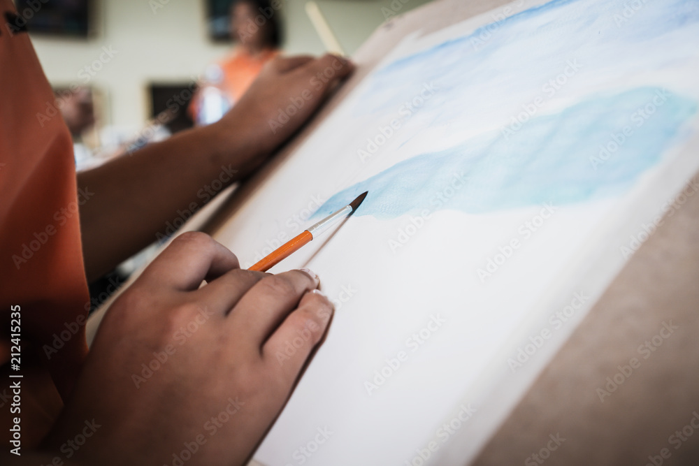Student's hand with brush drawing on paper for creation picture ...