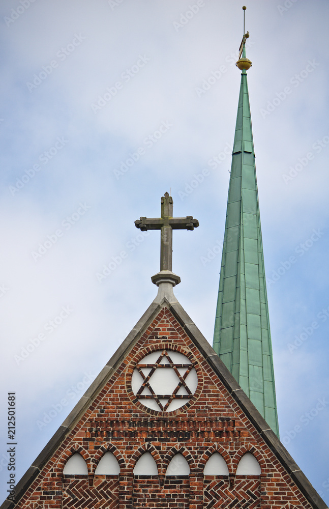 Church gable with Christian cross over a star of David with narrow ...