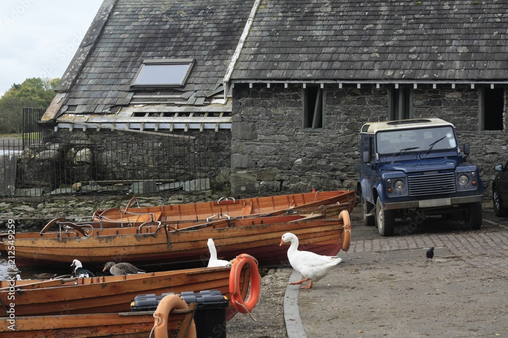 timber Boats pulled up onto a stone Jetty in the lake district, England ...