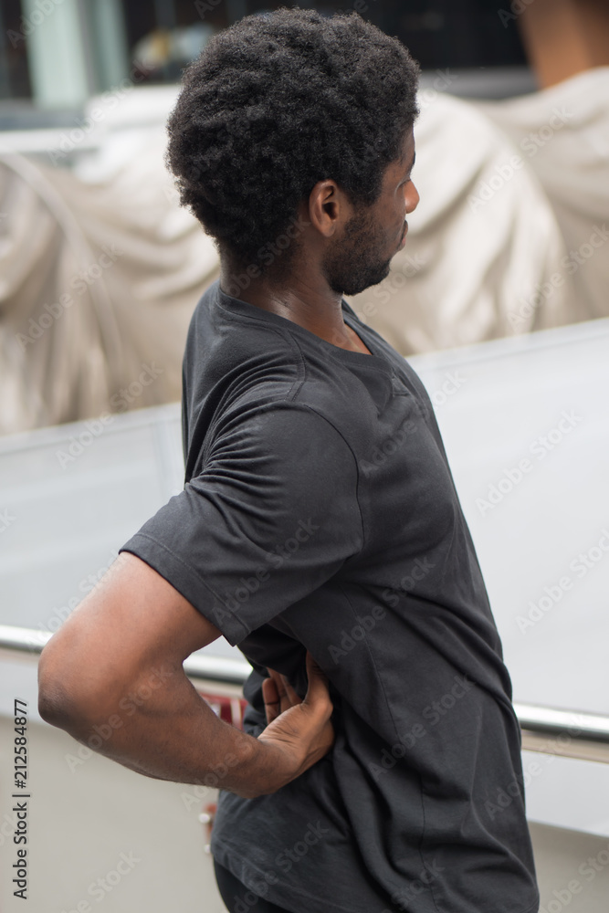 Foto de man suffering from back pain; sick african man with back joint ...