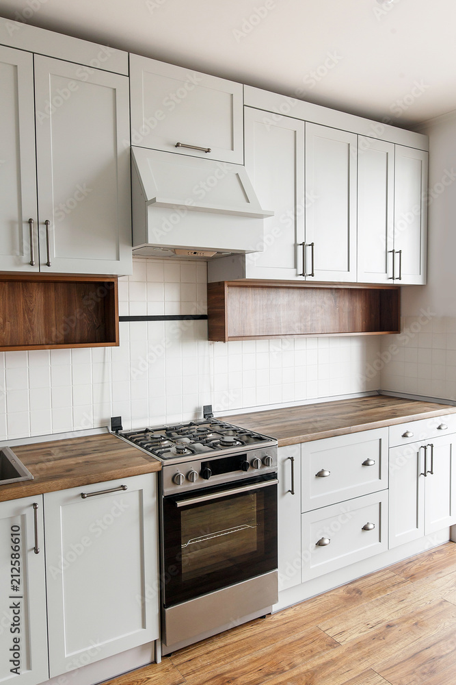 Stylish light gray kitchen interior with modern cabinets and stainless ...