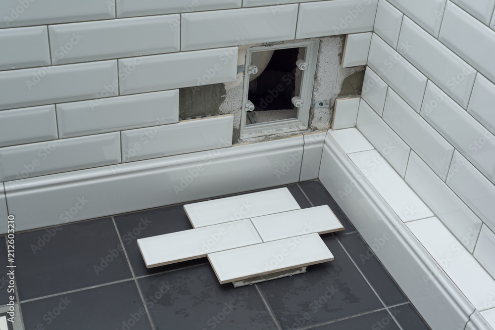 Open hidden revision sanitary hatch on the wall of tile under the ...