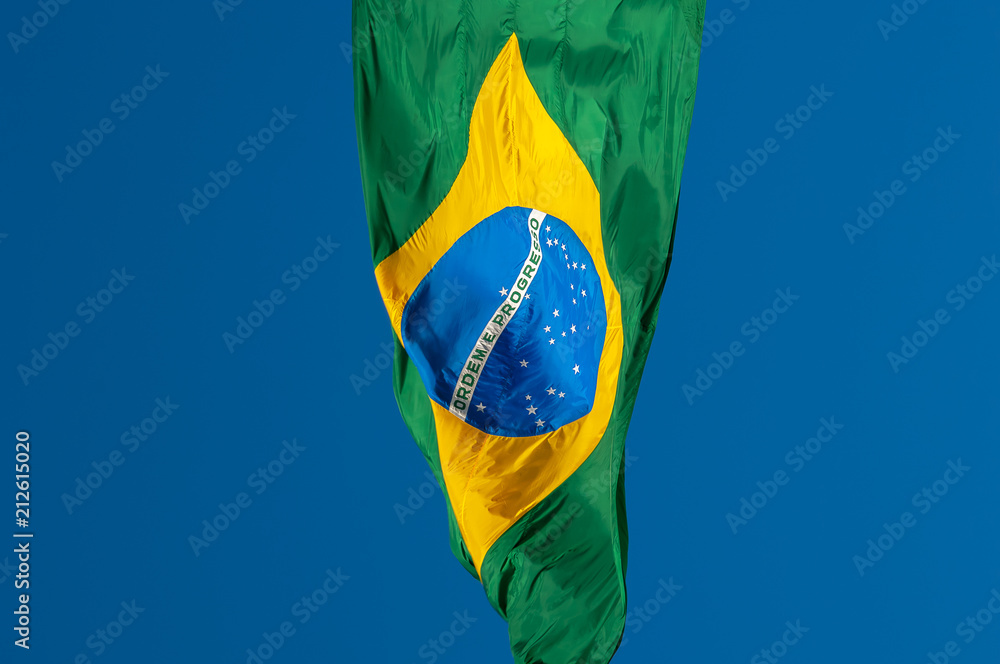 Brazil flag in the wind, contrasting with the blue sky, its colors ...