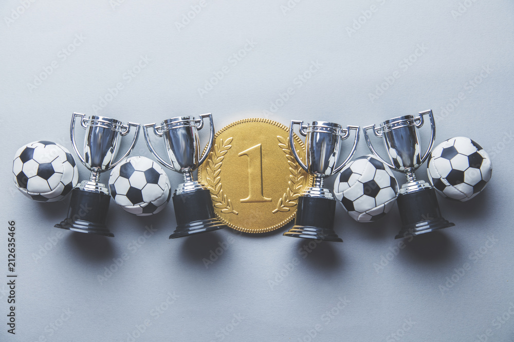 Gold first place winners medal and trophy with a soccer ball. Football ...
