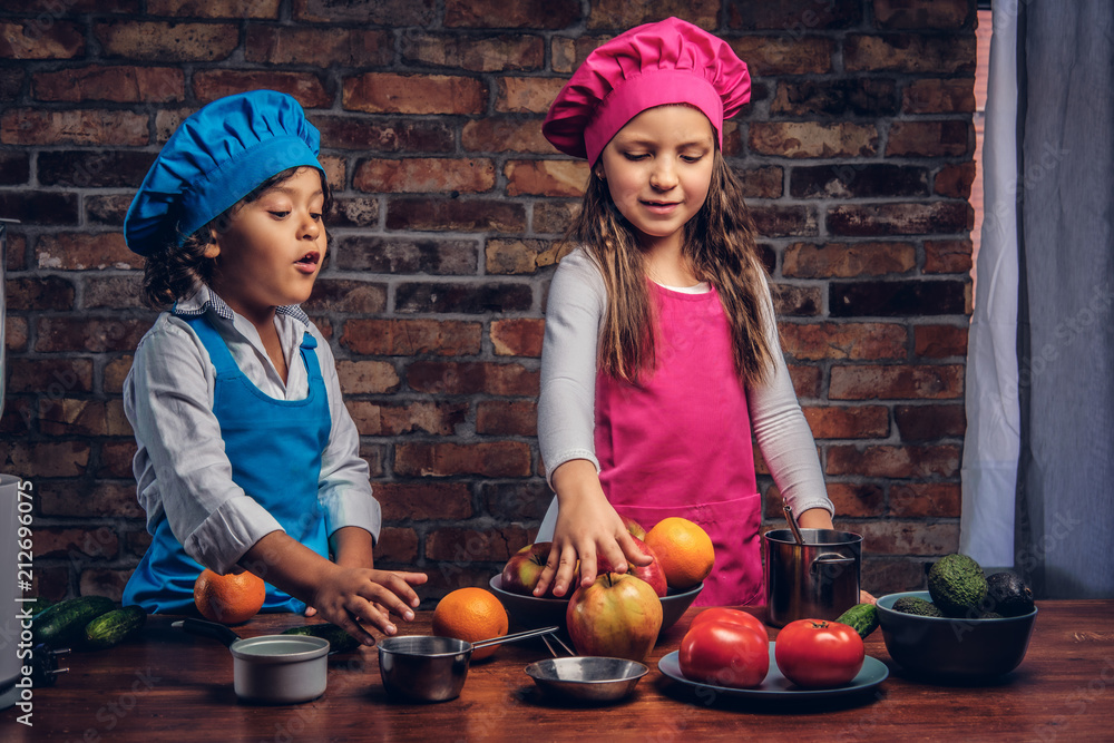 Cute cook couple. Little boy with brown curly hair dressed in a blue ...