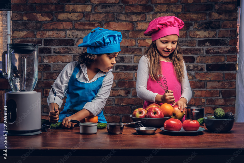 Cute cook couple. Little boy with brown curly hair dressed in a blue ...