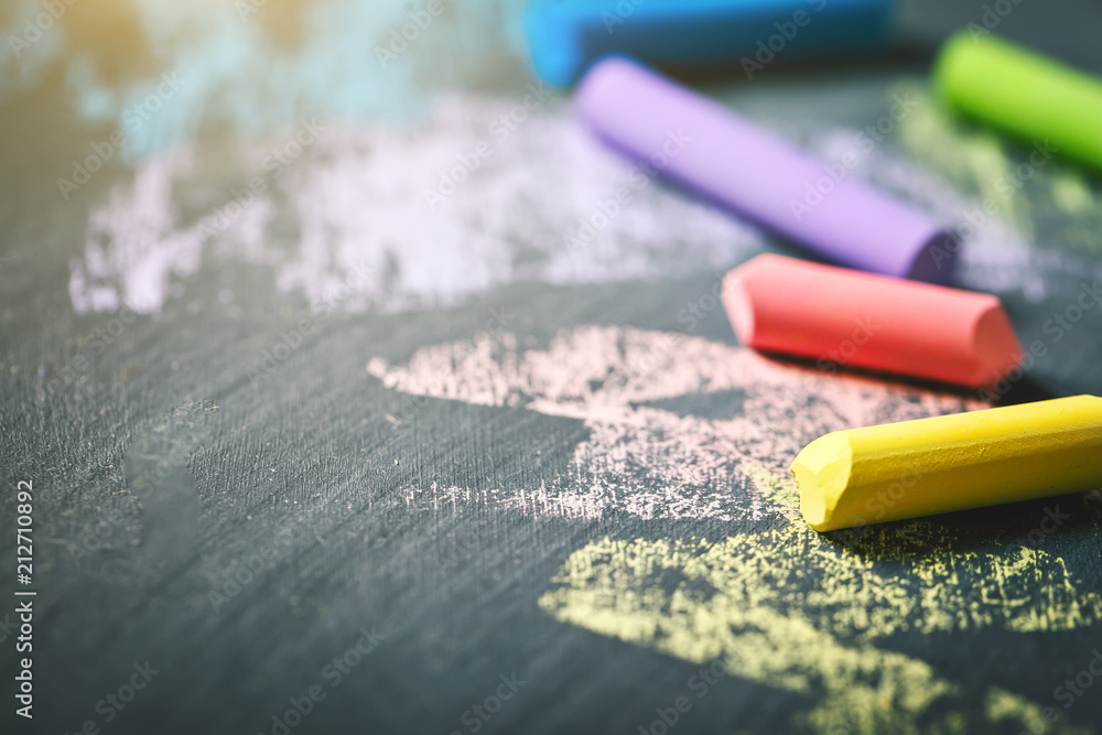 Colorful crayons on the blackboard, drawing. Back to school background ...