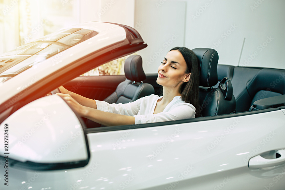 Relax in your own car. An attractive young woman sits behind the wheel ...