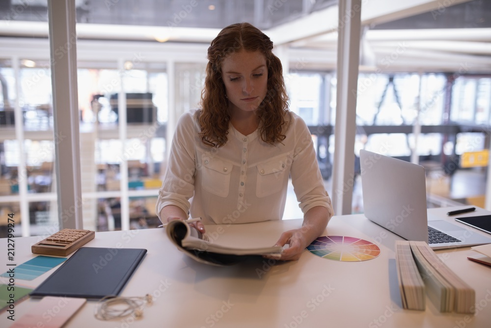 Female graphic designer reading a book Stock Photo | Adobe Stock