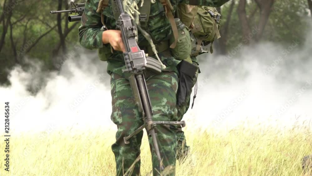 Soldier holding gun weapon and waring armor uniform. The military is ...