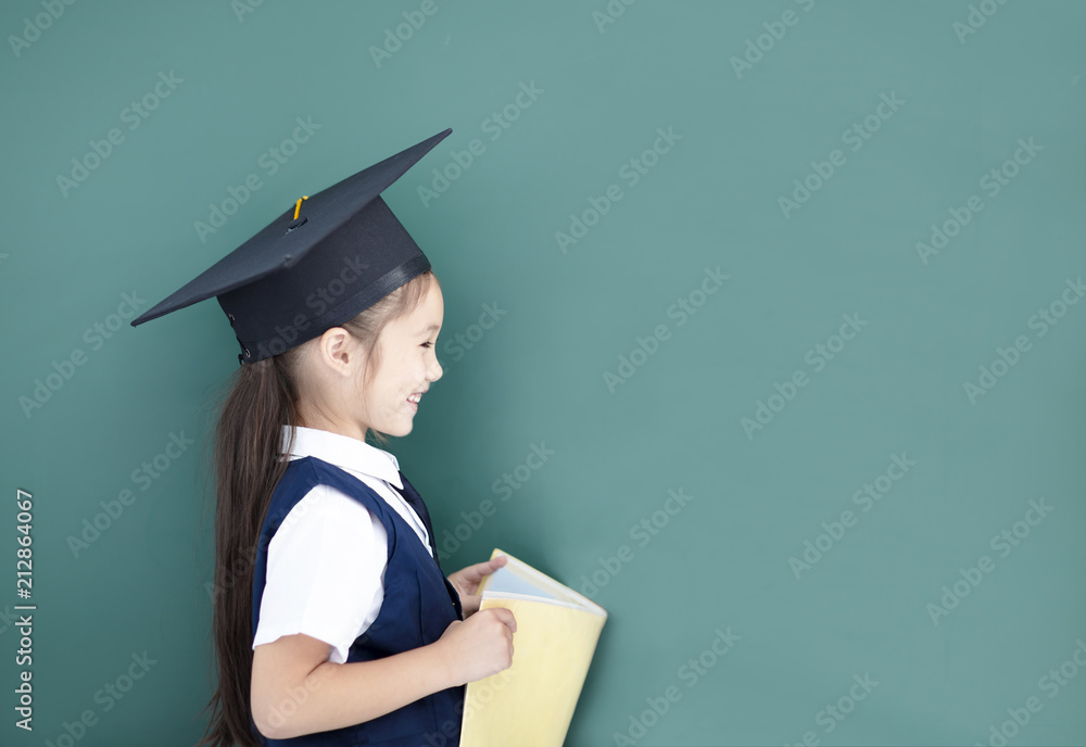 side view of little girl in graduation cap and studying Stock Photo ...
