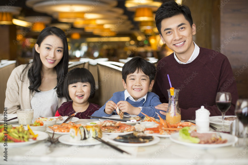 Cheerful young Chinese family having buffet dinner Stock Photo | Adobe ...