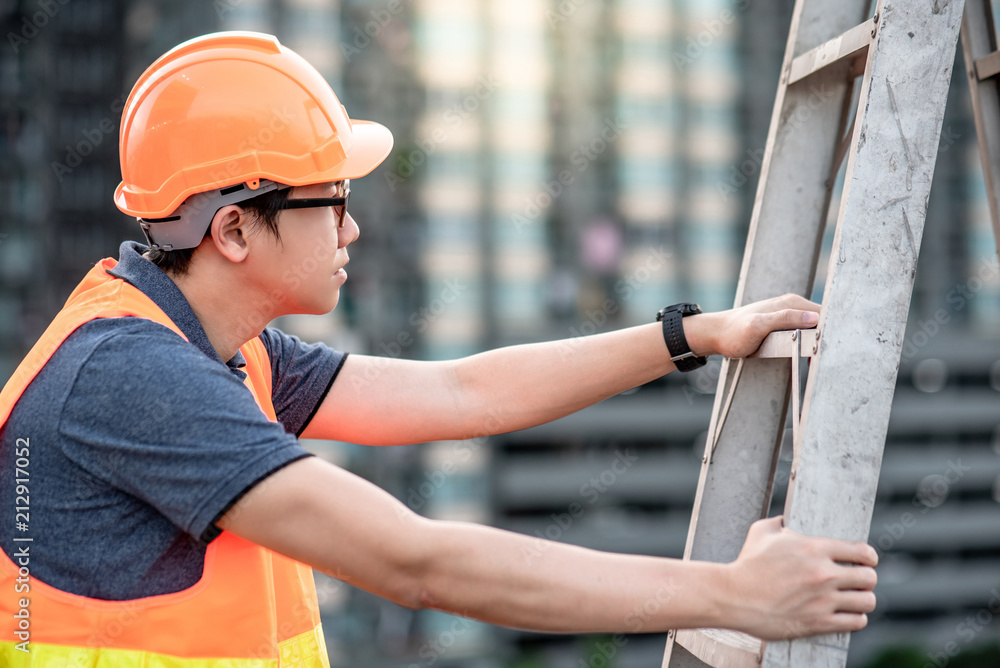 Young Asian maintenance worker with orange safety helmet and vest ...