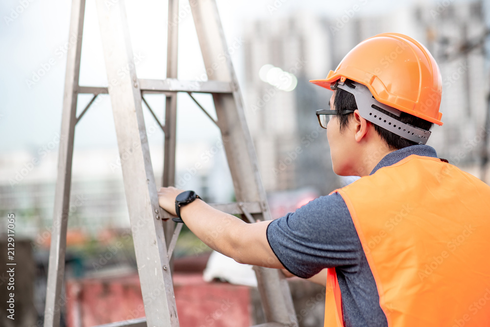 Young Asian maintenance worker with orange safety helmet and vest ...