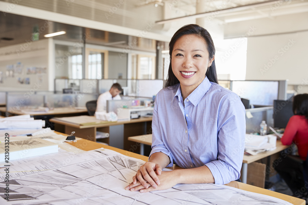 Female Asian architect smiling to camera in open plan office Stock ...