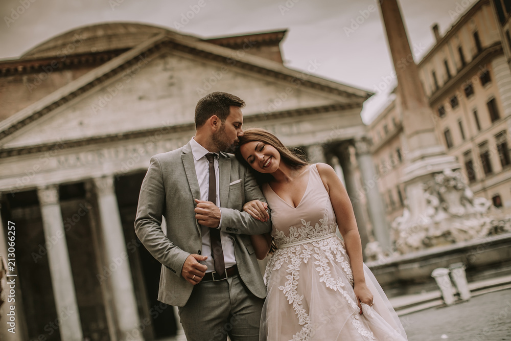 Young newly married couple posing in Rome with beautiful and ancient ...