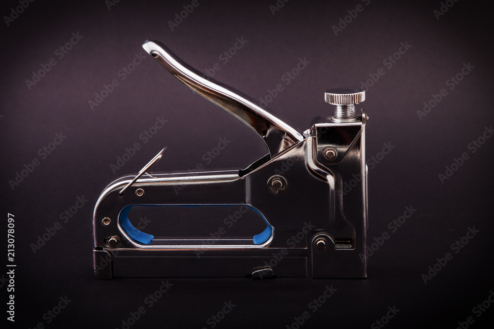 Stainless steel construction stapler isolated on black background in ...