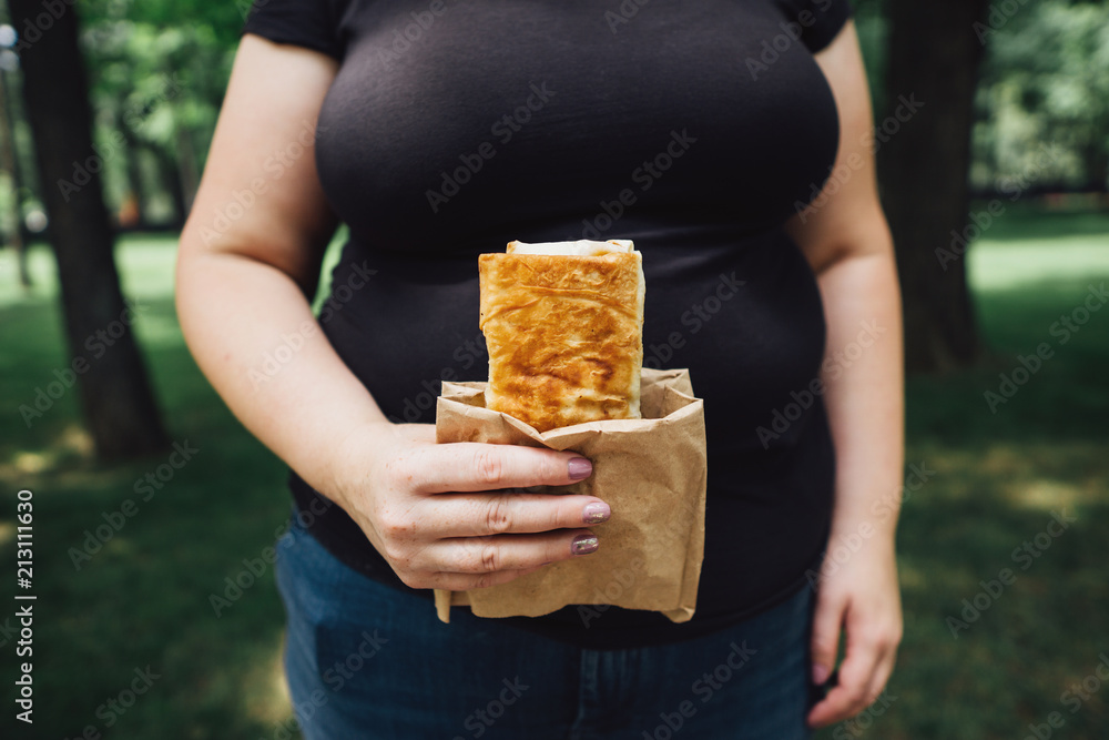 Fattening food, snack on the go, unhealthy lunch. Overweight woman ...