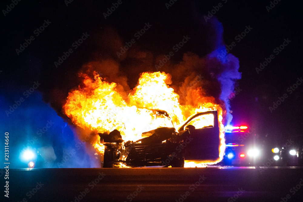 Car on fire at night with police lights in background Stock Photo ...
