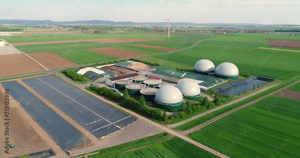 Camera flight over biogas plant from pig farm. Renewable energy from biomass. Modern agriculture ...
