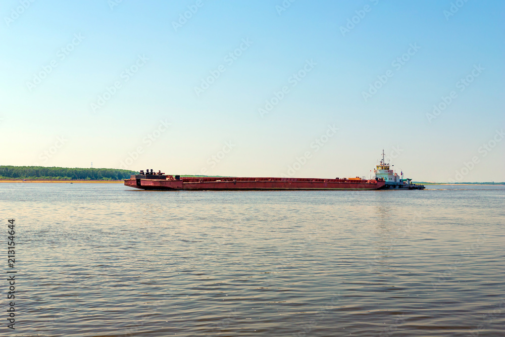 Fotografia do Stock: The tugboat pulls an empty barge in front of him ...