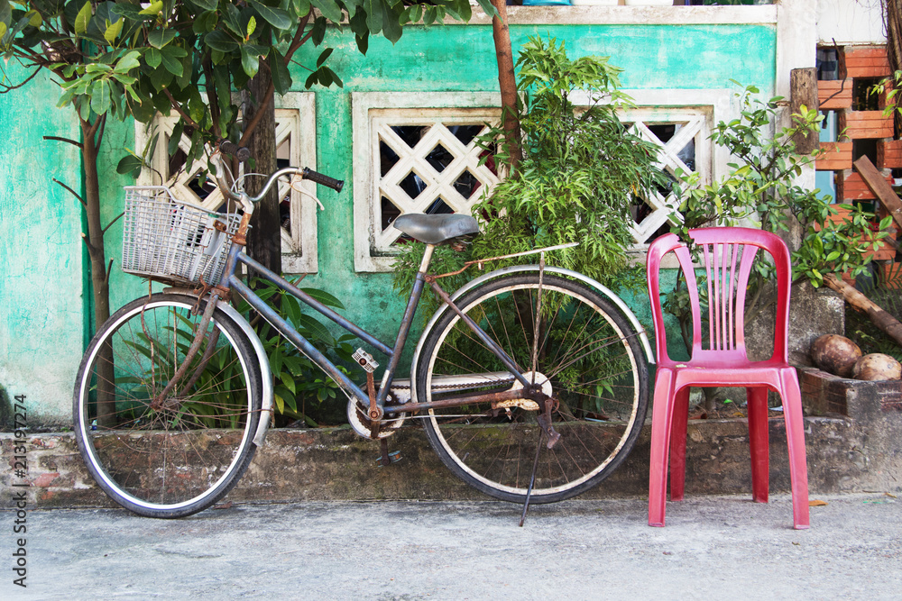 Old bicycle and a red plastic chair with asian architecture Stock Photo ...