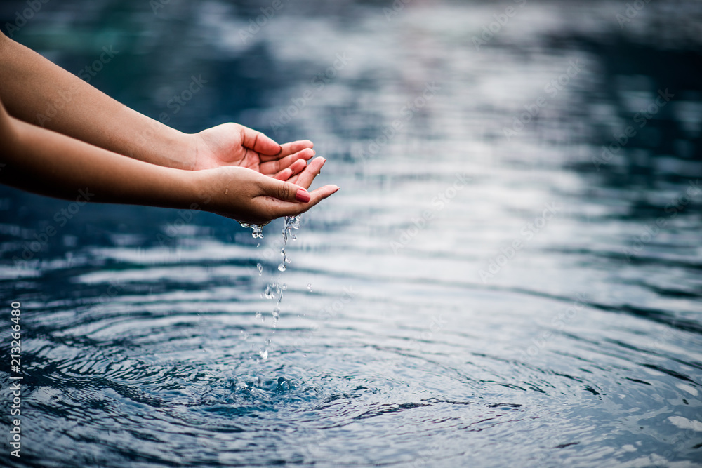 The hand that touches the blue water. The pool is clean and bright ...
