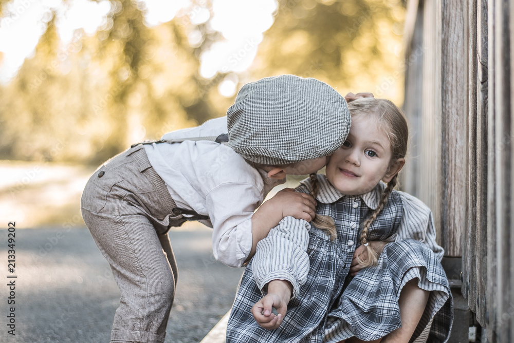 Foto Stock Junge gibt Mädchen Kuss auf die Wange | Adobe Stock