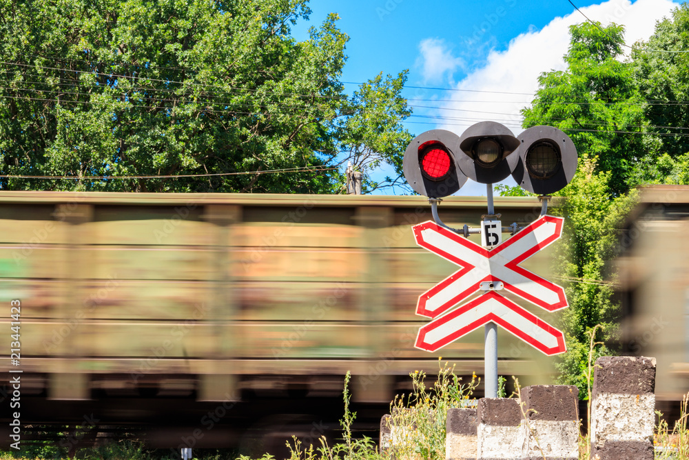 Red signal of semaphore and stop sign in front of railroad crossing ...
