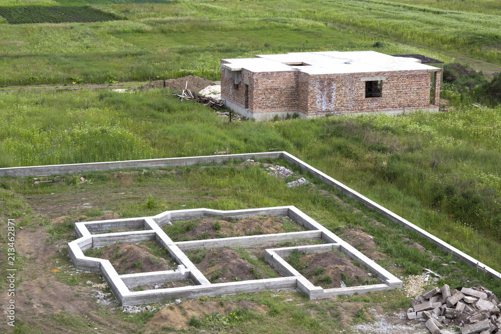 Building site in green field. Trenches dug in ground and filled with ...