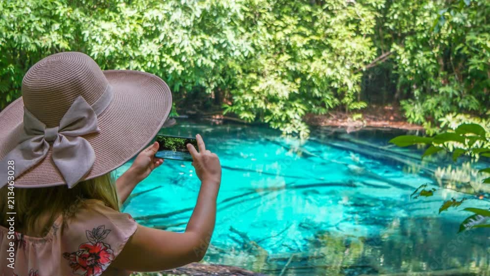 Cinemagraph of Female Tourist in Hat Using Cell Phone for Taking Photo ...