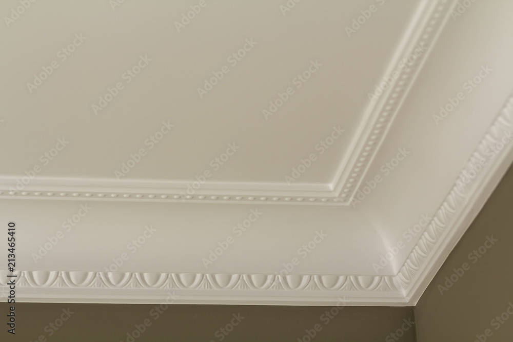 Ornamental white molding decor on ceiling of white room close-up detail ...