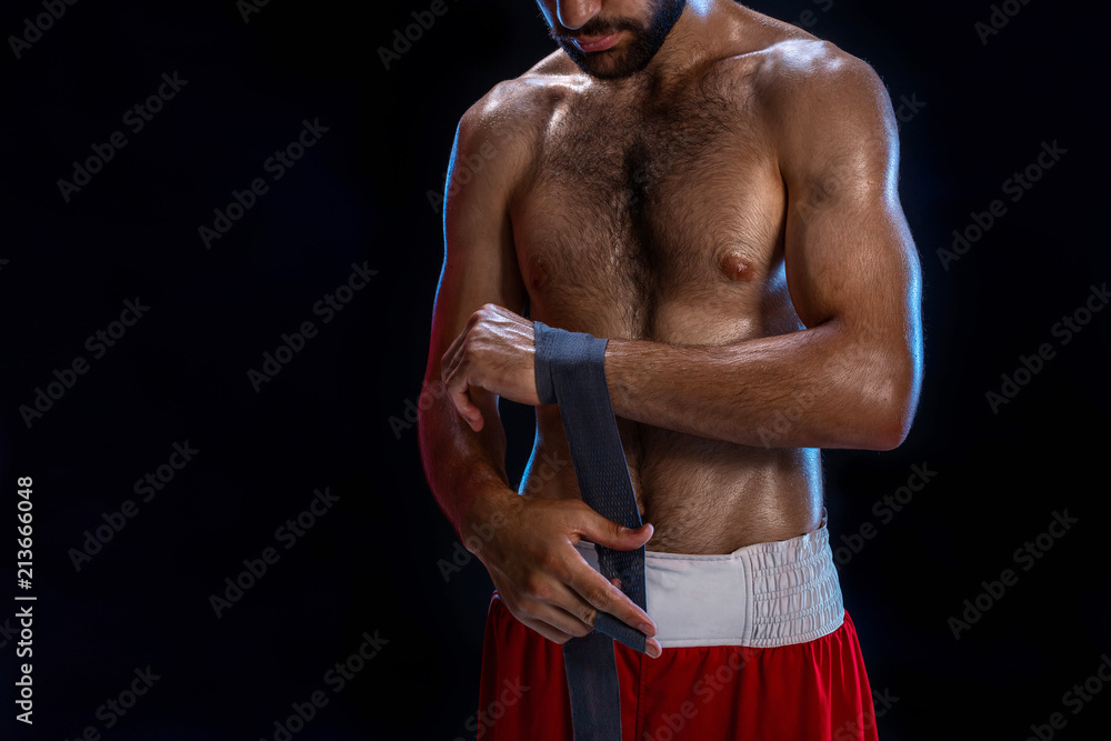 Boxer preparing her gloves for a fight. Photo of muscular man strapping ...