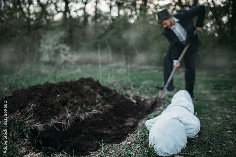 Poster Killer is digging a grave for the victim in forest – Wall Art ...