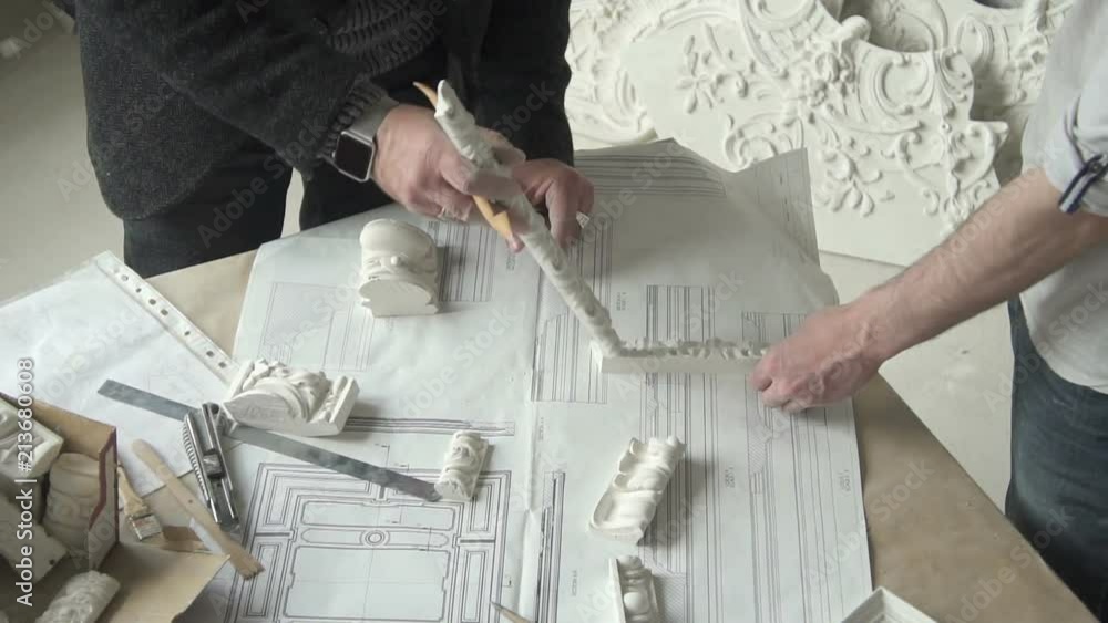 Hands of two male designers choosing molding samples for their project ...