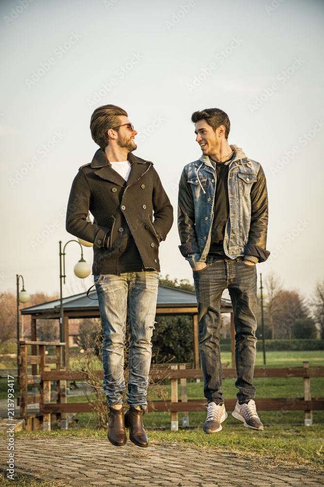 Pair of Young Men Leaping into Air with High Jump in Unison While ...