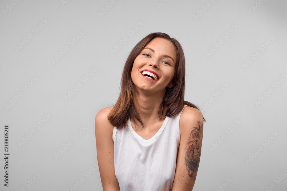 Smiling positive female with attractive look, wearing loose white T ...