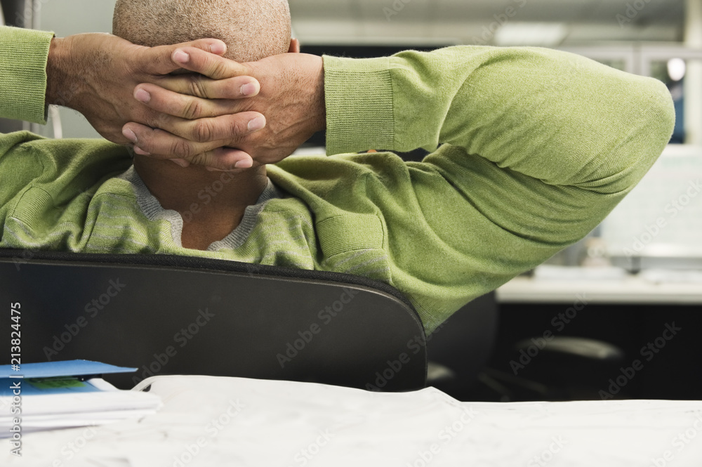 Closeup view from behind of a Black man in a cubicle office with hands ...