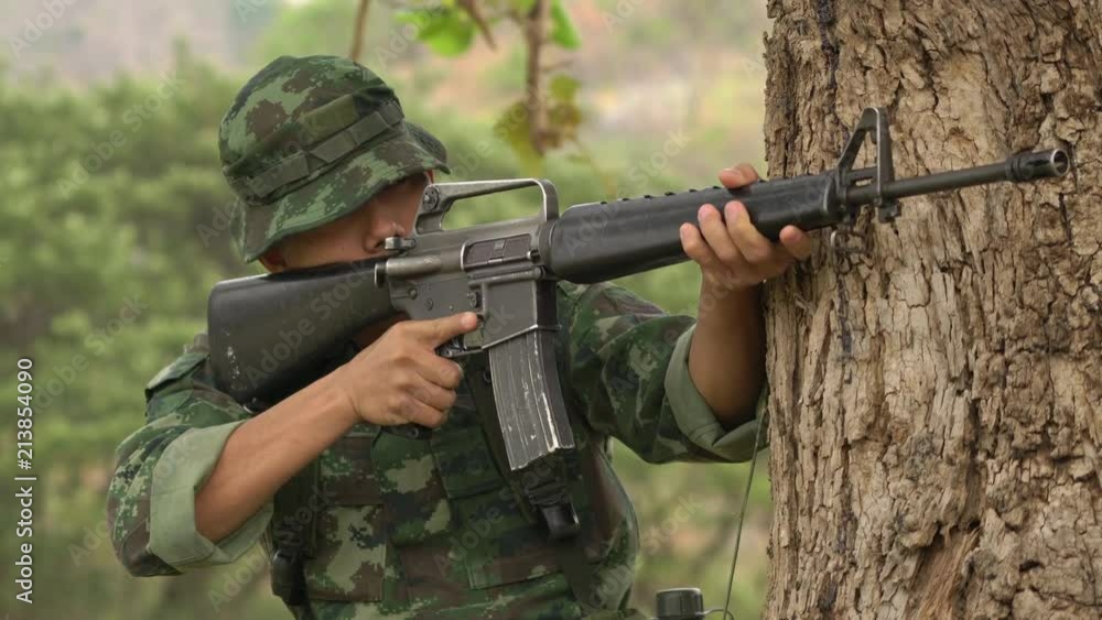 Soldier holding gun weapon and waring armor uniform. The military is ...
