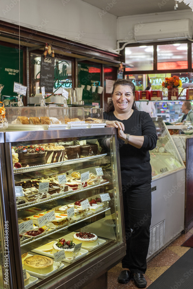 Owner of neighborhood Italian bakery in New York City smiling and ...