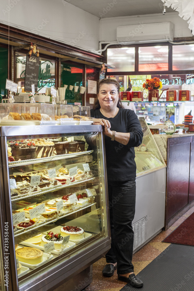 Owner of neighborhood Italian bakery in New York City smiling and ...