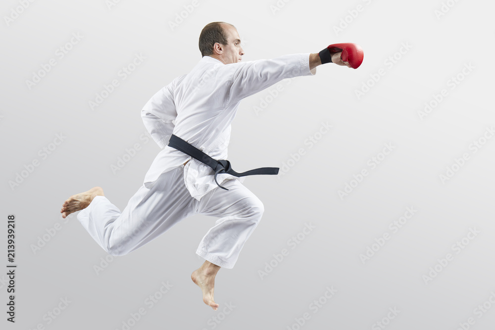An adult athlete with red overlays on his hands beats with a hand in a ...