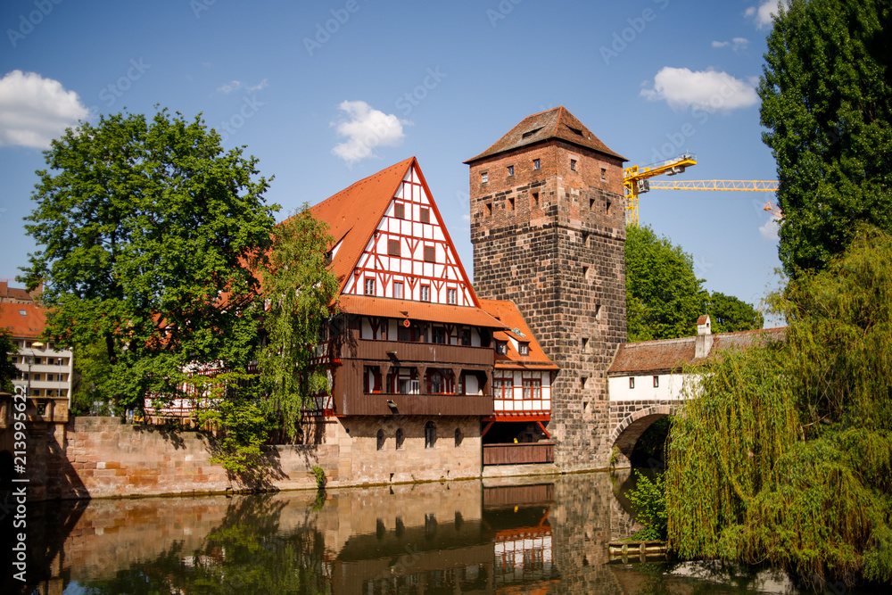 Bridge over the Pegnitz river with a traditional half-timbered house ...
