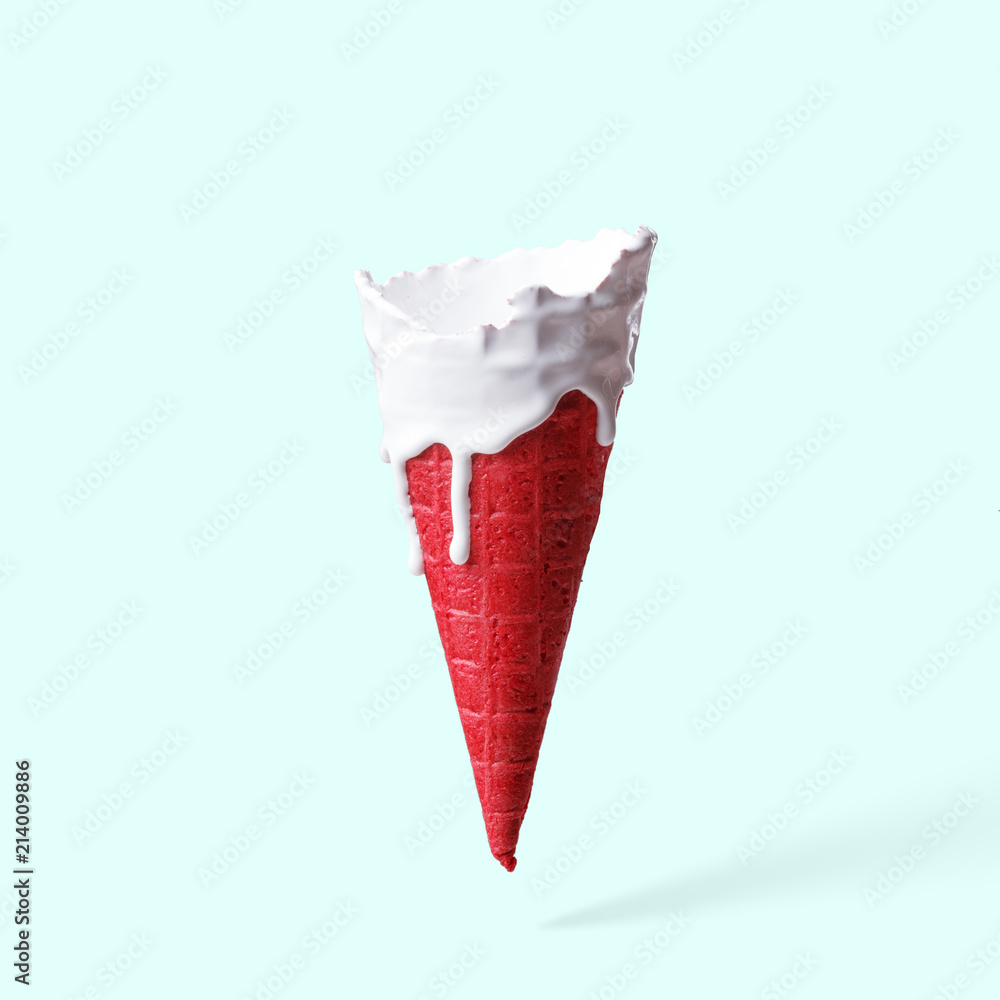 A red cone for ice cream in the dripping white paint on a light blue ...