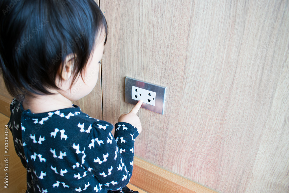 A child is trying to poke into electrical outlets. Kid with electrical ...