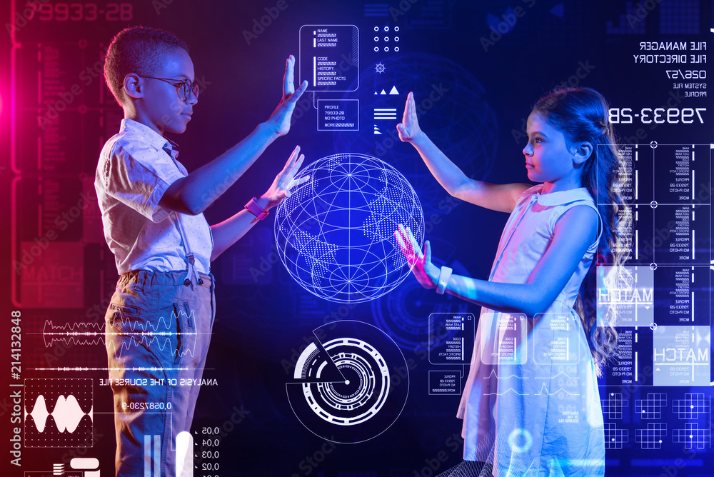 Exploring new devices. Clever progressive schoolchildren standing ... Exploring new devices. Clever progressive schoolchildren standing ...